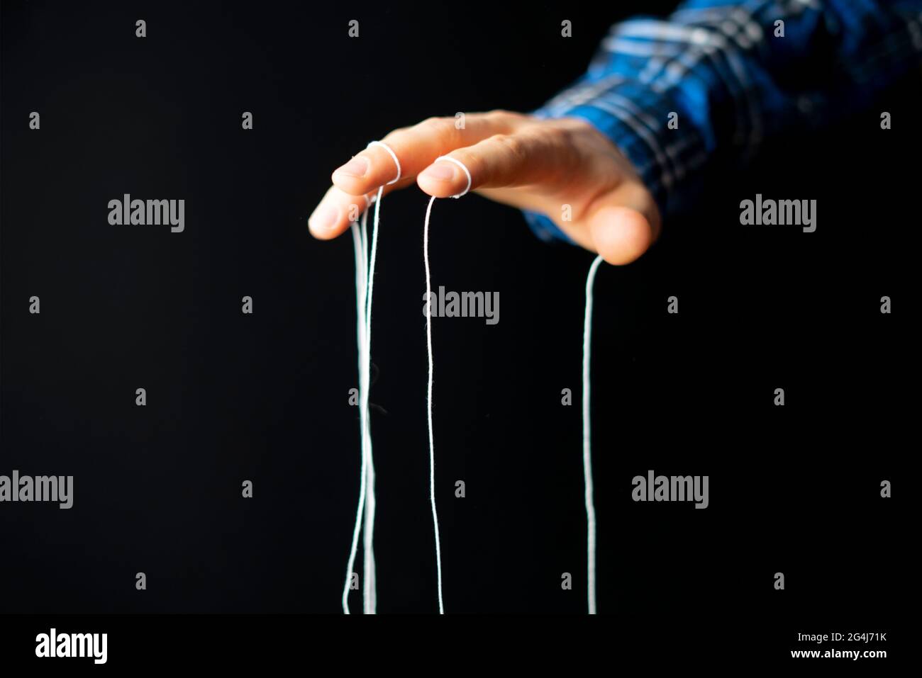 puppeteer's hand with ropes on fingers control the people mind concept ...