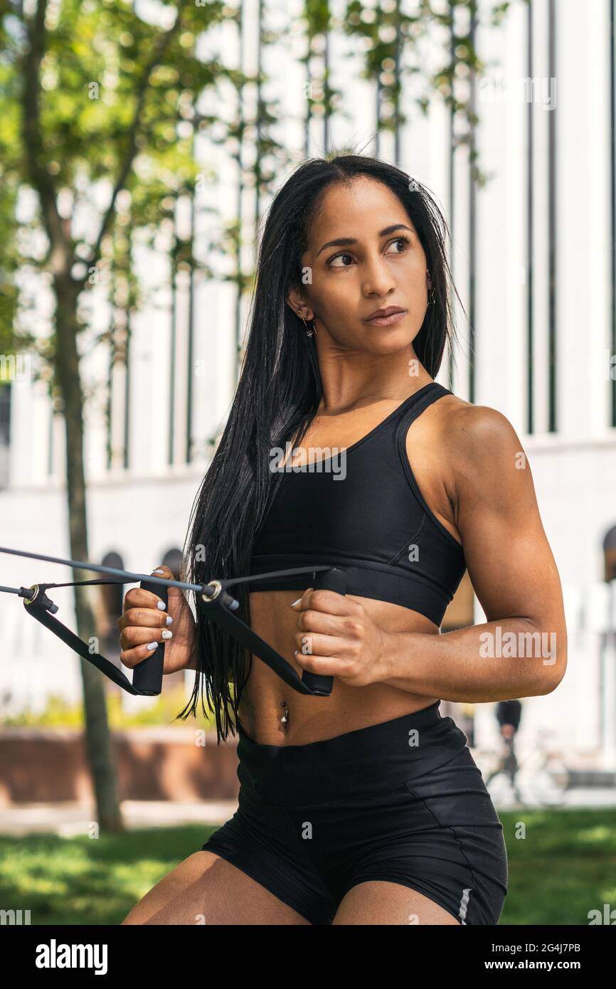 Fitness woman using a resistance band. Bodybuilder girl workout in the ...