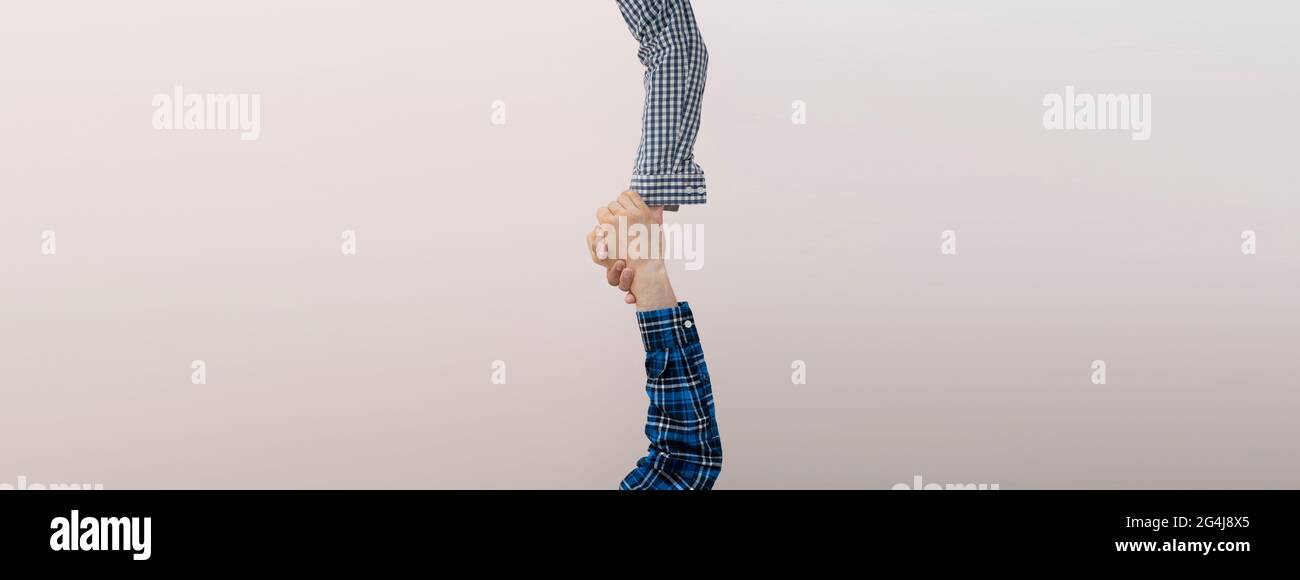 two hands support each other, handshake, isolated against the colorful ...