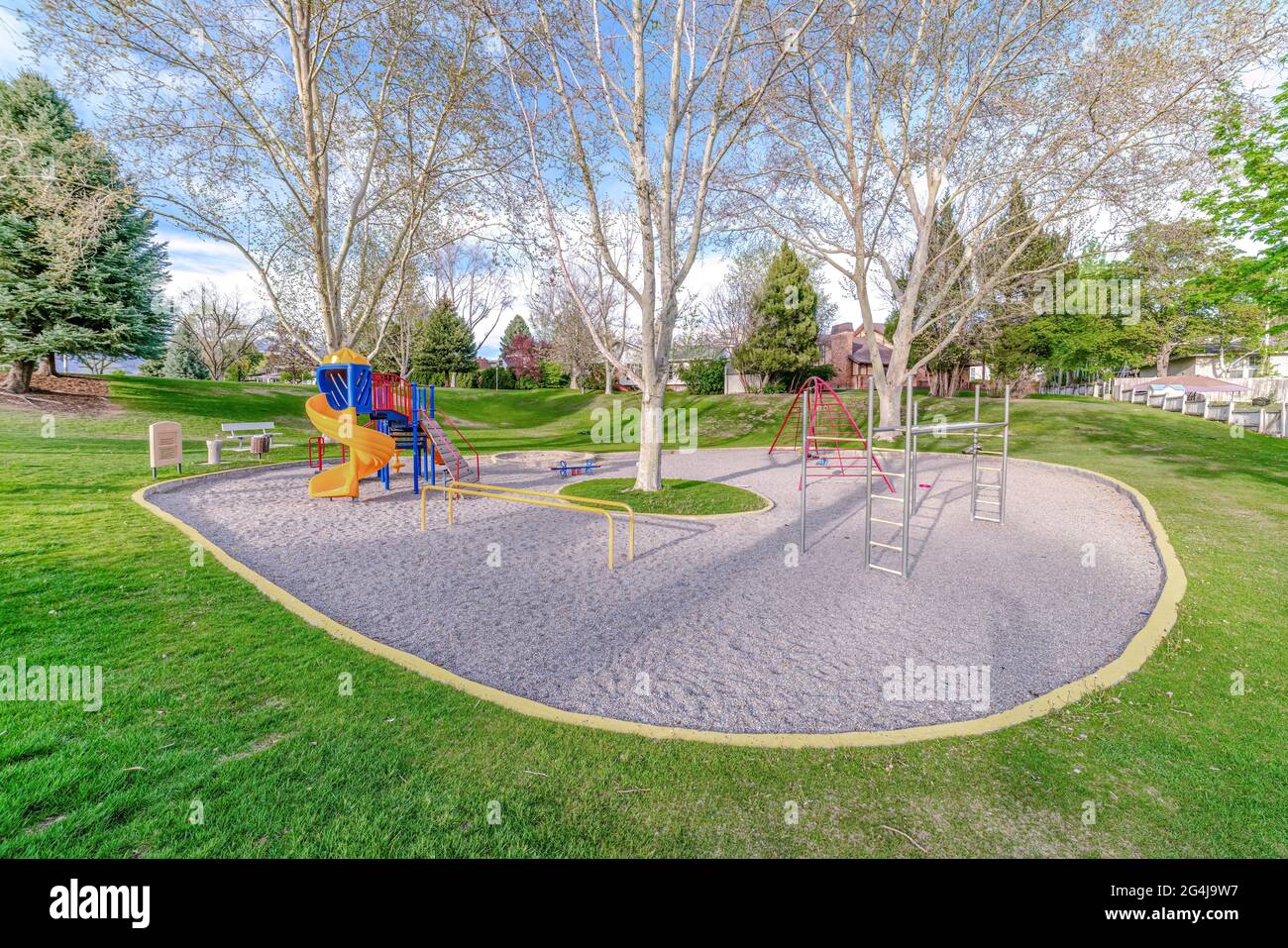 Small playground with a slide in a park Stock Photo - Alamy