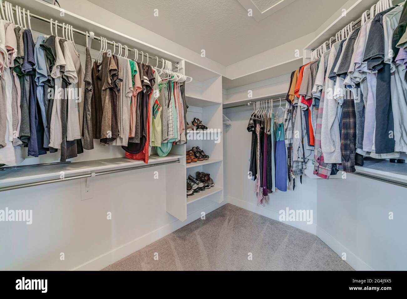 Clothes in a wardrobe room with white wooden shelves and racks Stock ...