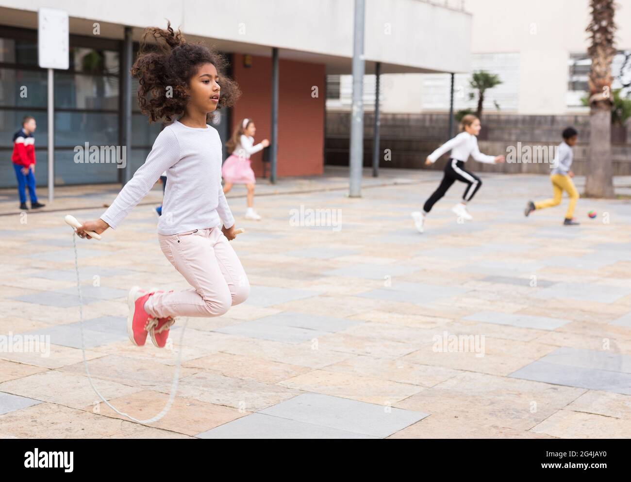Tween African American girl skipping rope in schoolyard Stock Photo - Alamy