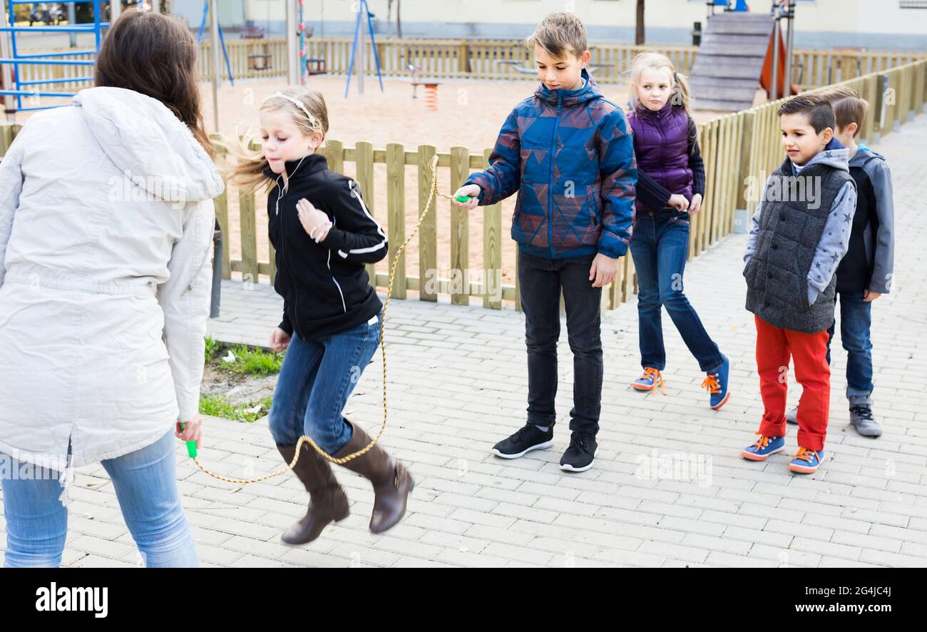 Children playing rubber band jumping game and laughing Stock Photo - Alamy