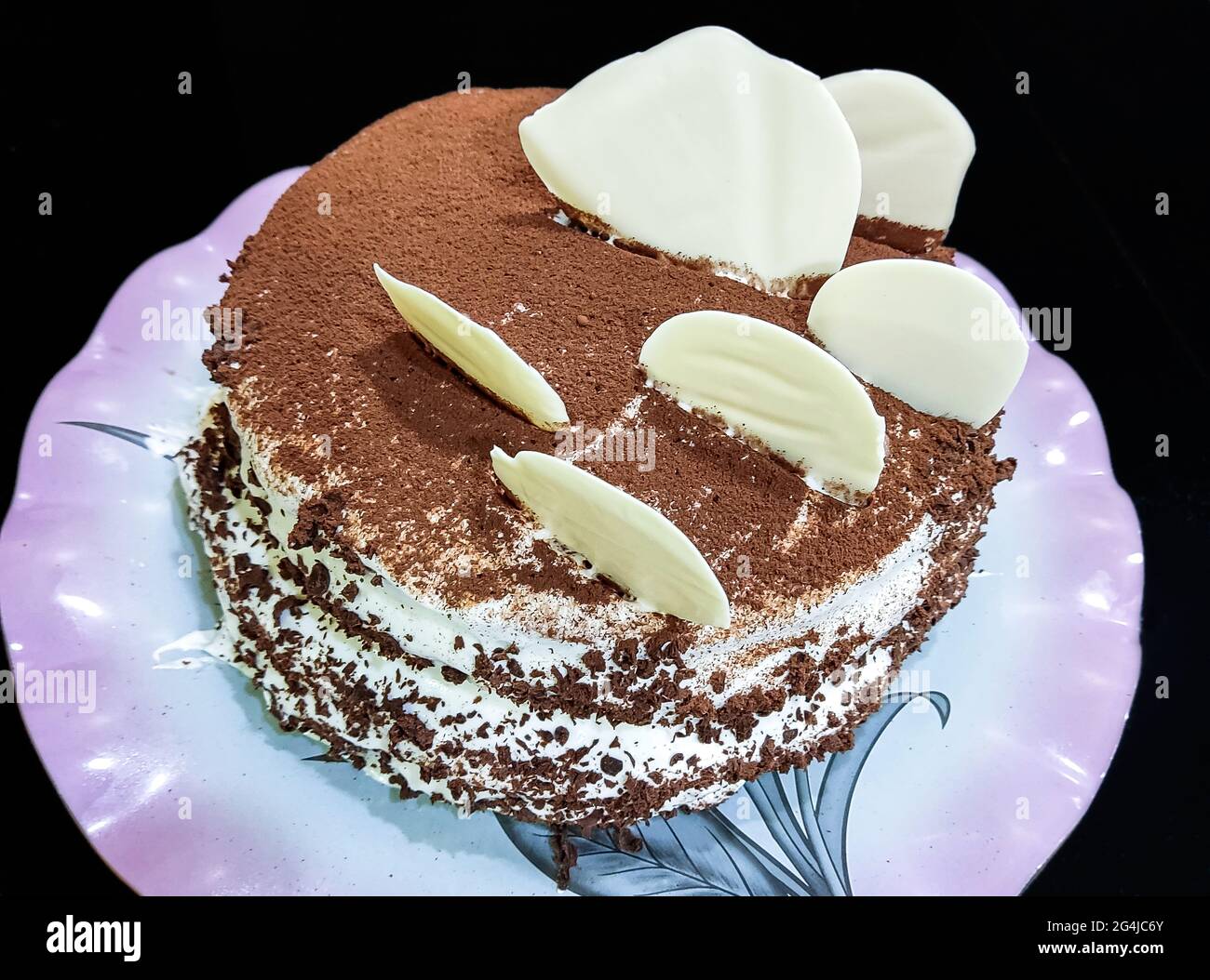Homemade biscuit cake with chocolate on a plate isolated on a black ...