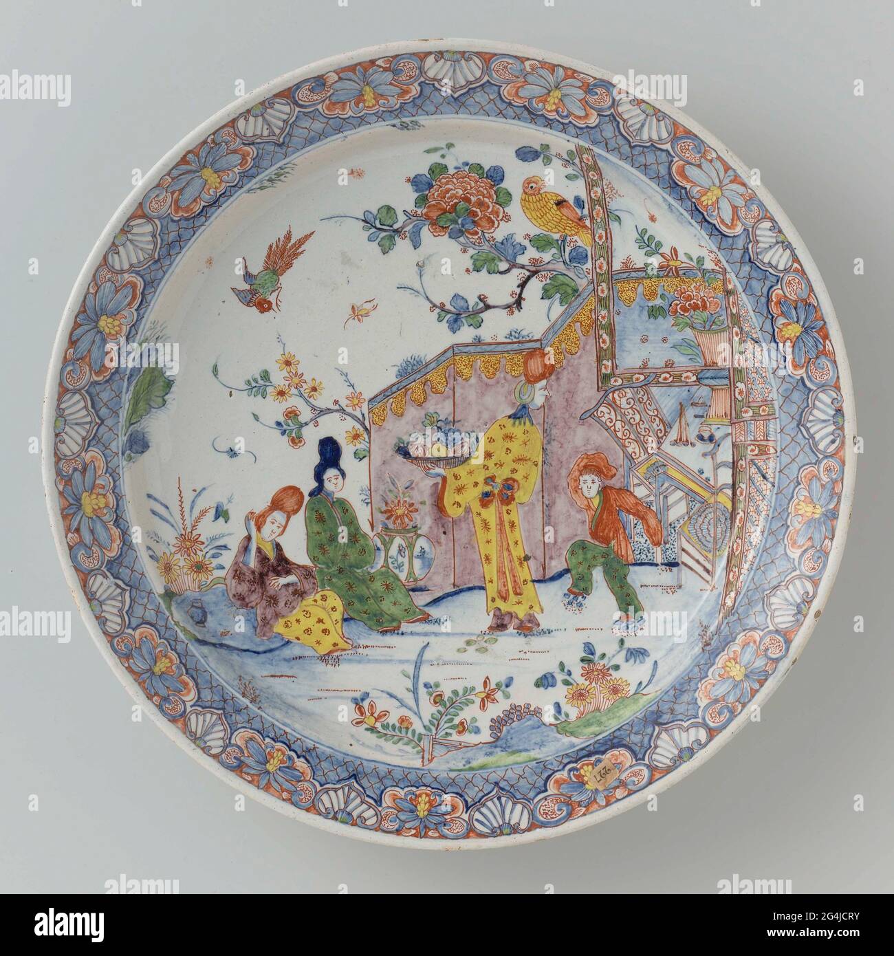 . Dish of Faïence, painted multi-colored with four Chinese. The edge ...