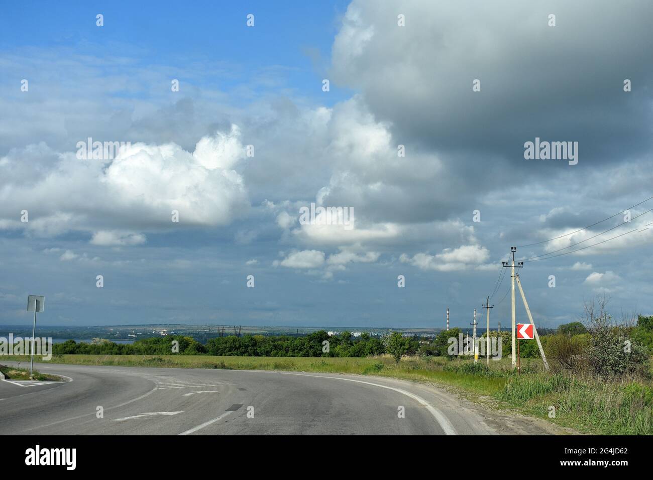 Empty street surrounded by vegetation with a cloudy sky over it Stock ...