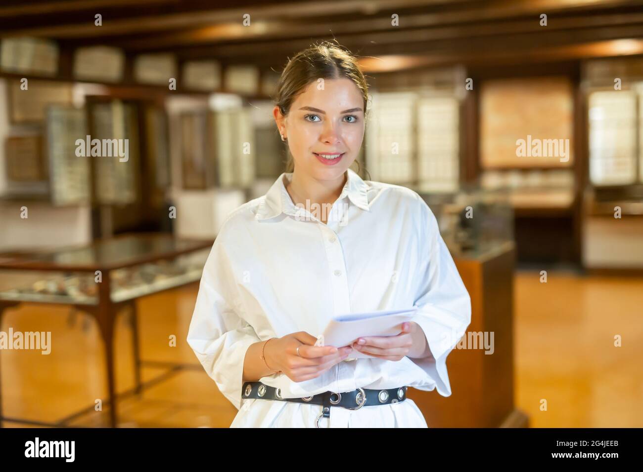 Positive woman in hall of historical museum Stock Photo - Alamy