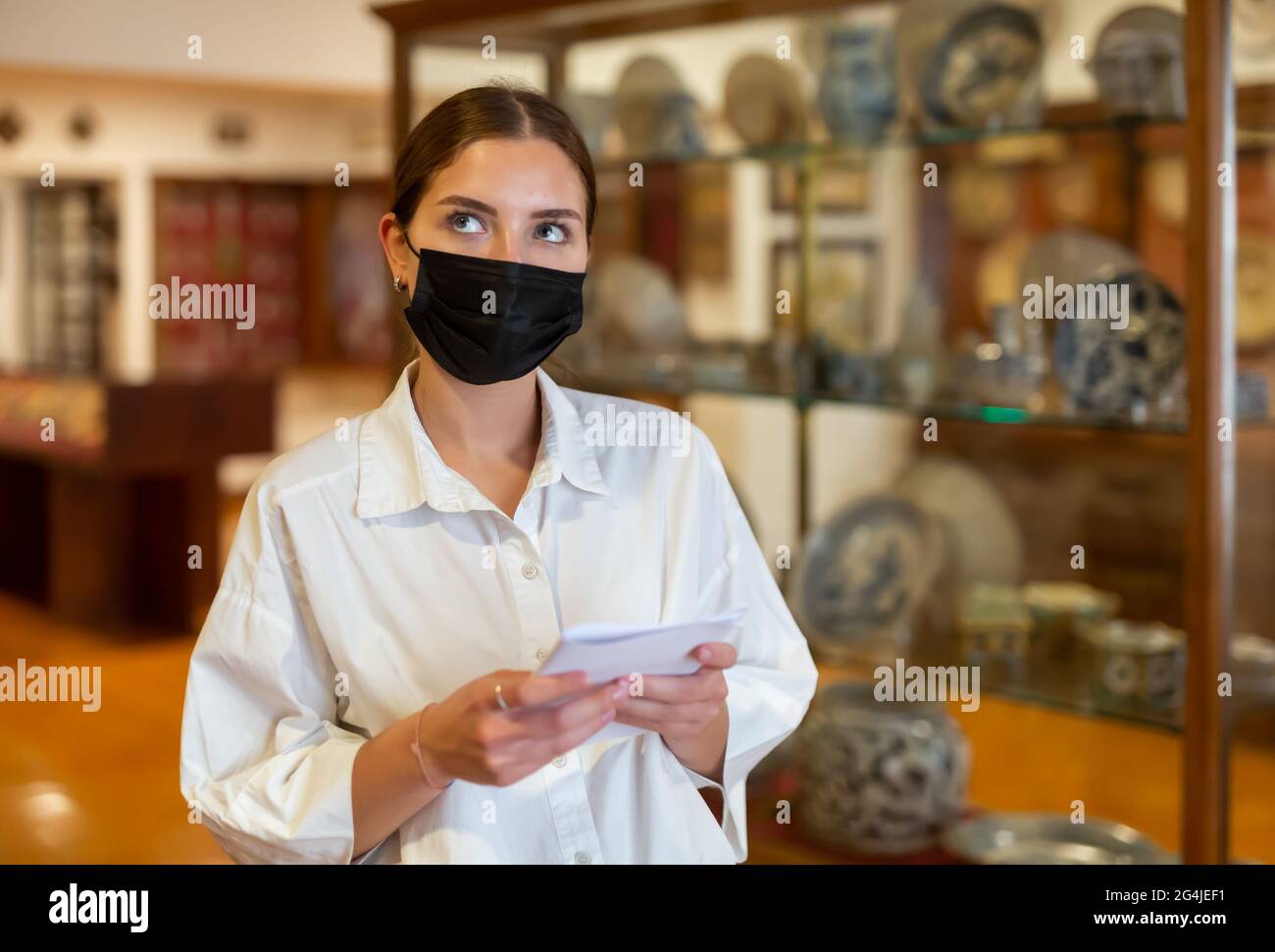 Woman wearing face mask observing artworks in museum Stock Photo - Alamy