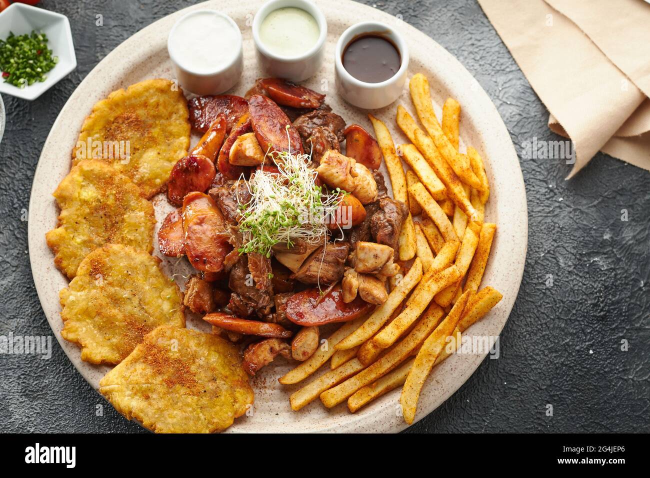 Top view of a plate with grilled meat, sauces, and french fries Stock ...