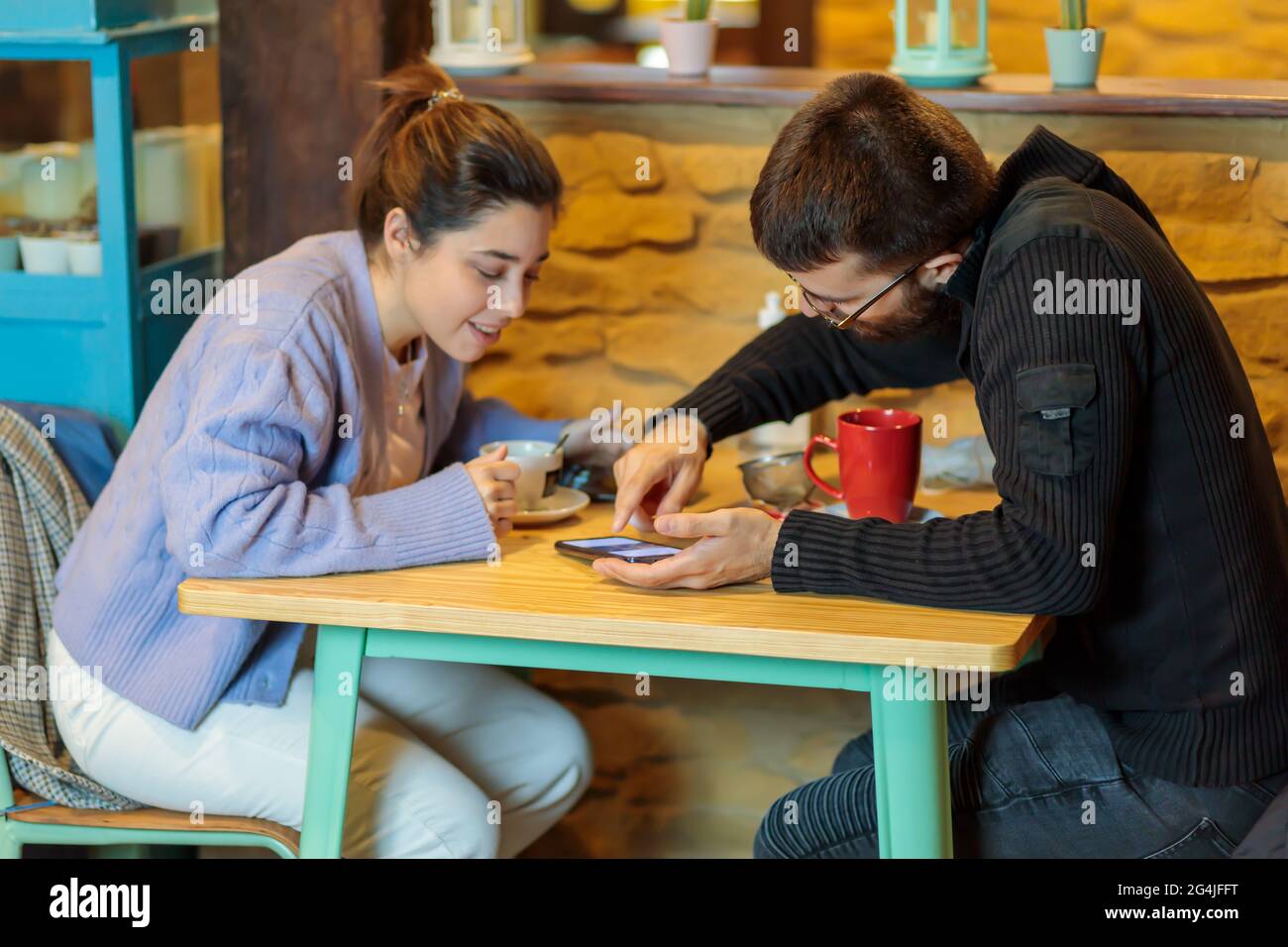Hispanic guy and a Caucasian lady sitting at a cozy cafe having hot ...