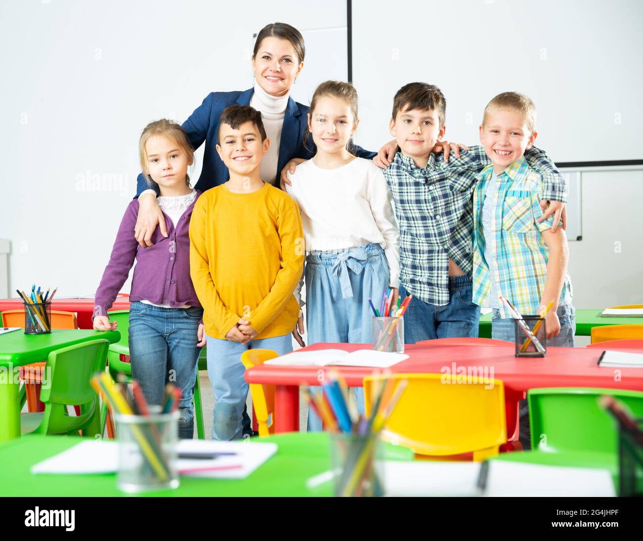 Teacher and happy children in classroom Stock Photo - Alamy