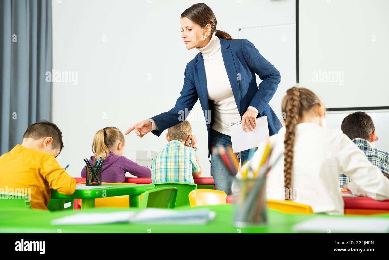 Little children working with teacher in classroom Stock Photo - Alamy