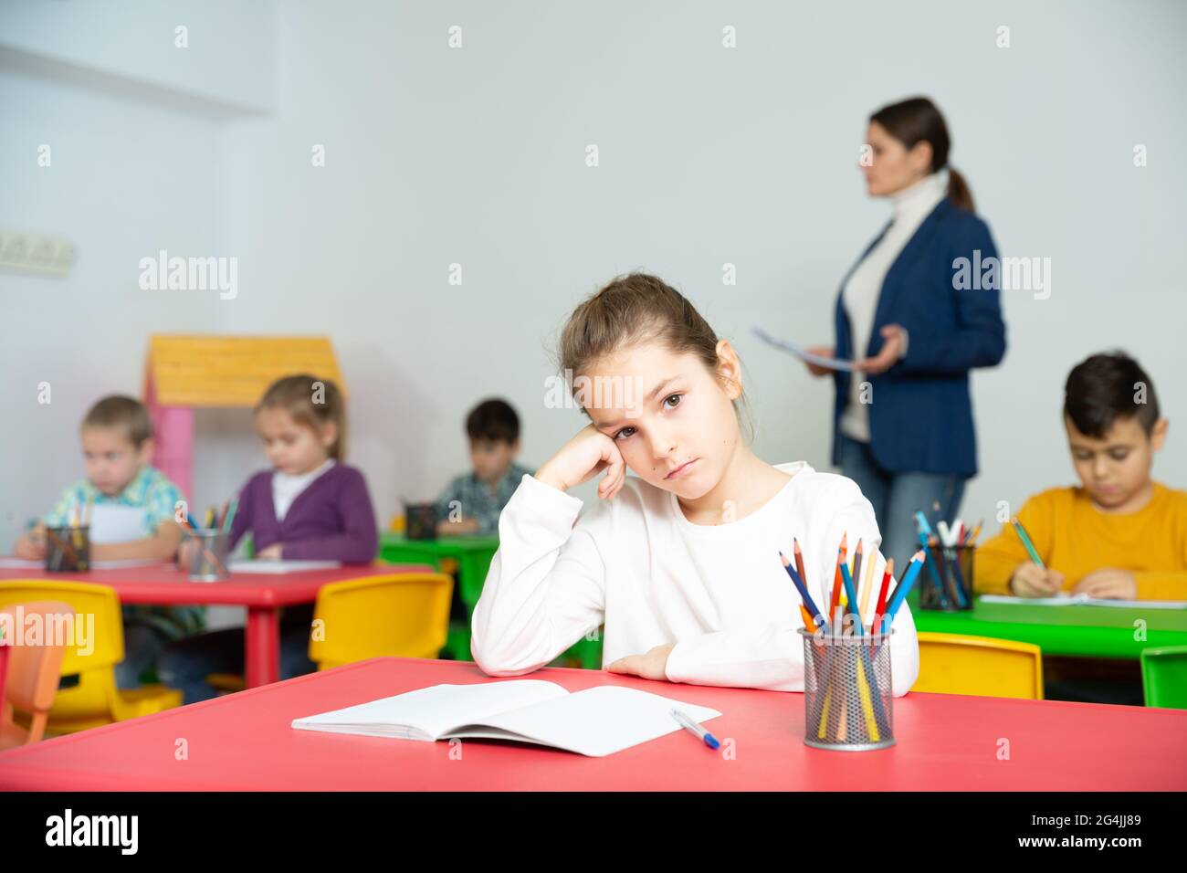 Sad schoolgirl in classroom during lesson Stock Photo - Alamy