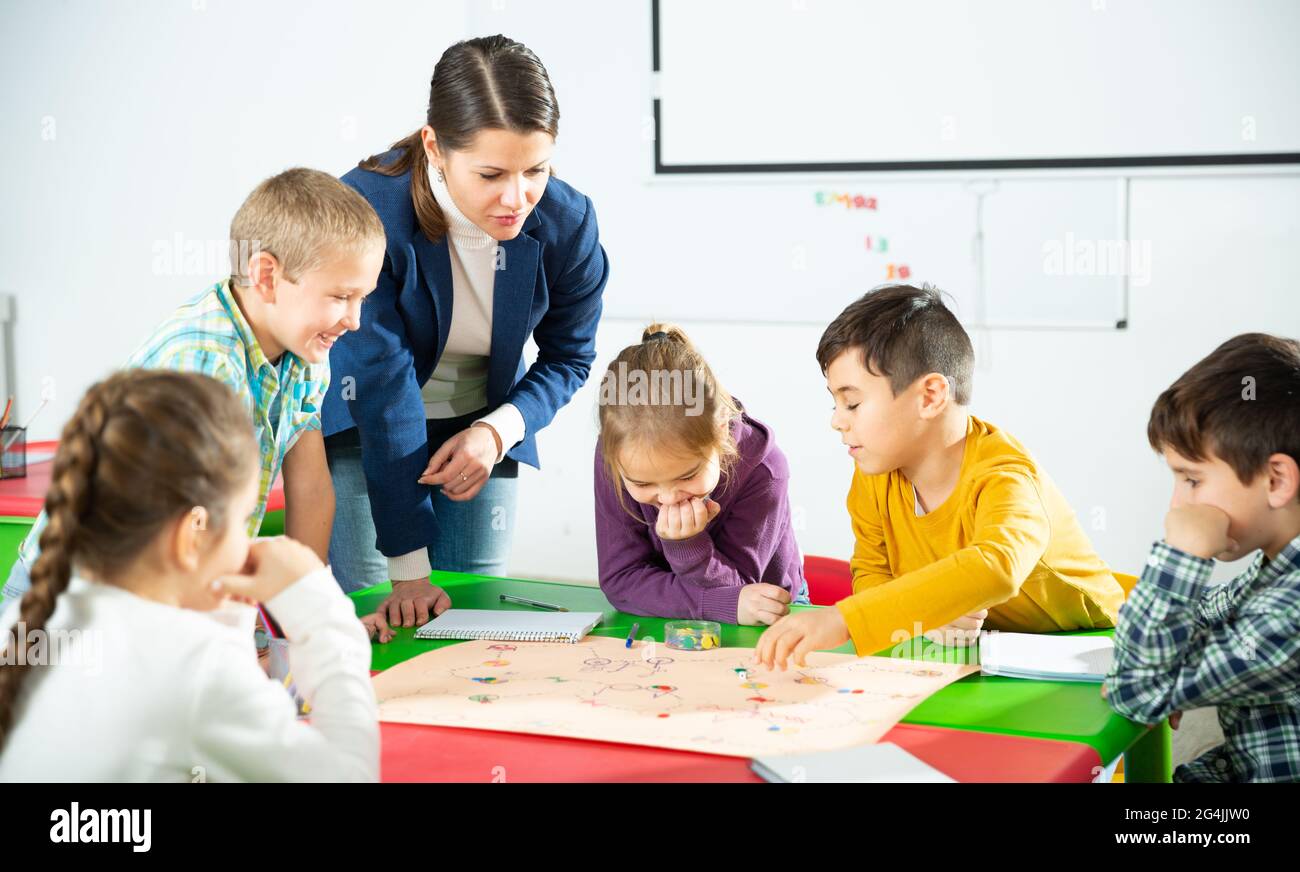 Teacher and pupils play a table game in elementary school class Stock ...