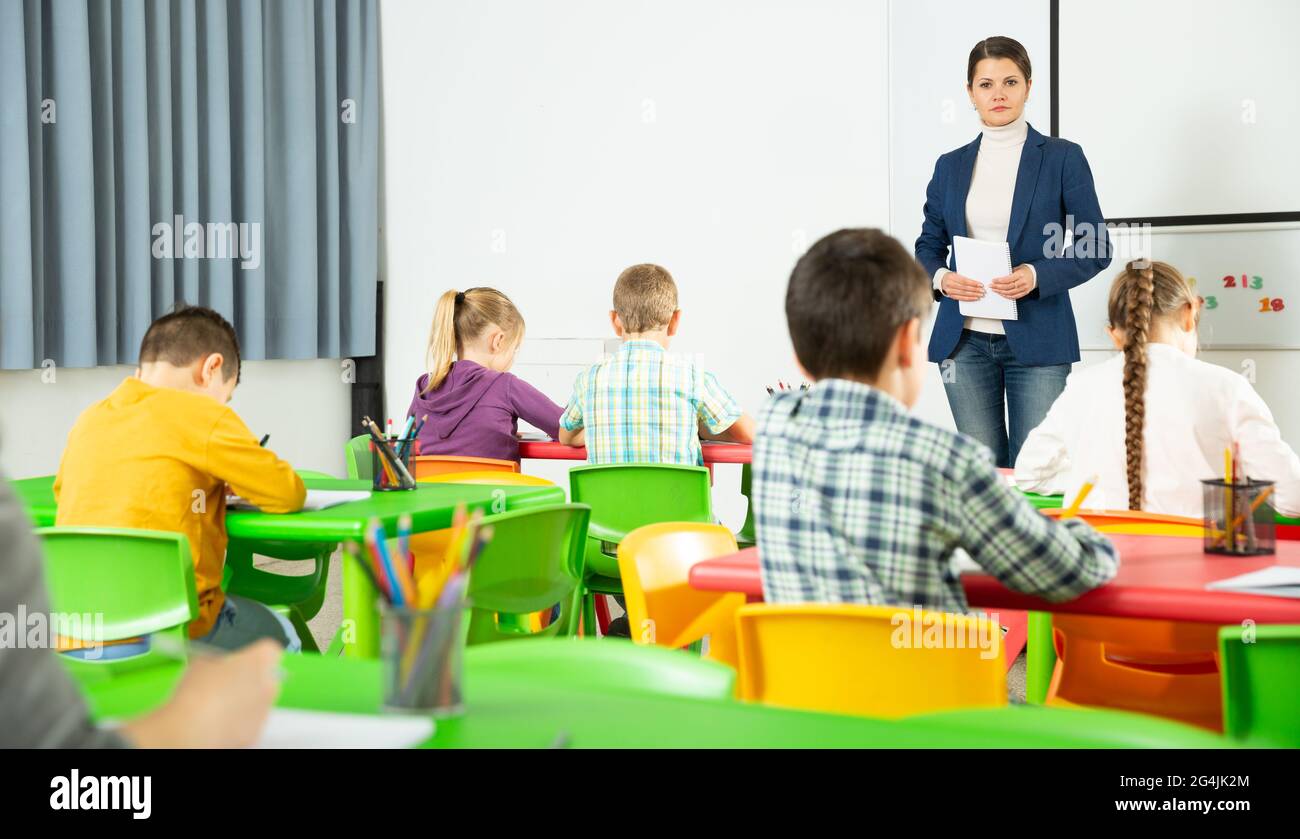 Teacher conducting lesson for children Stock Photo - Alamy