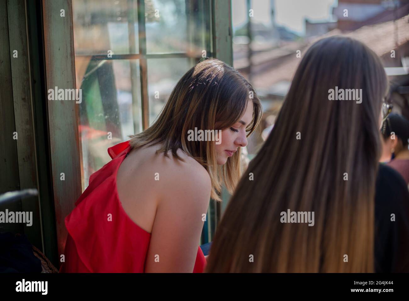 Back view of two female friends sitting and talking Stock Photo - Alamy