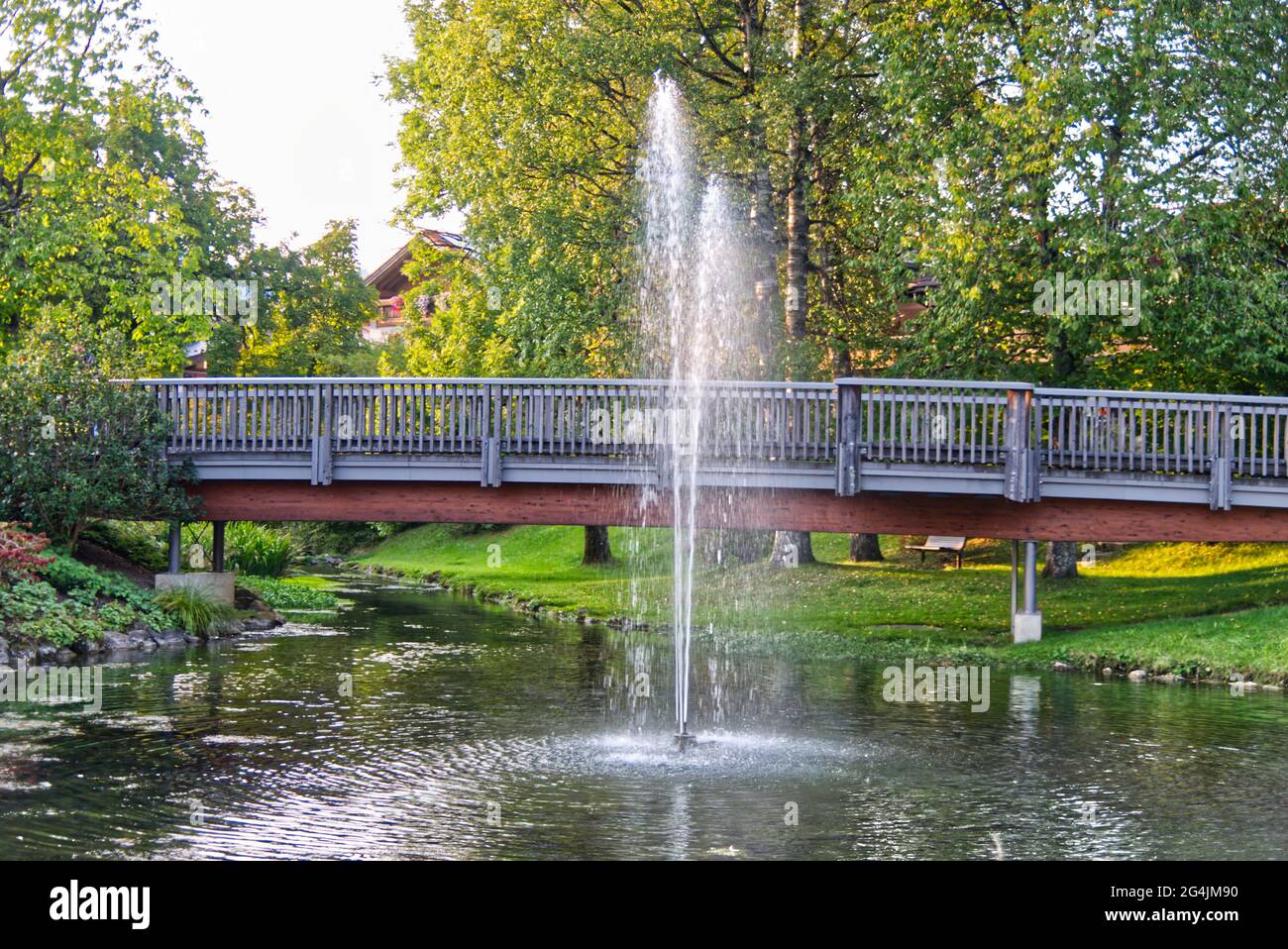 Beautiful park with a bridge over a river and a fountain splash Stock ...