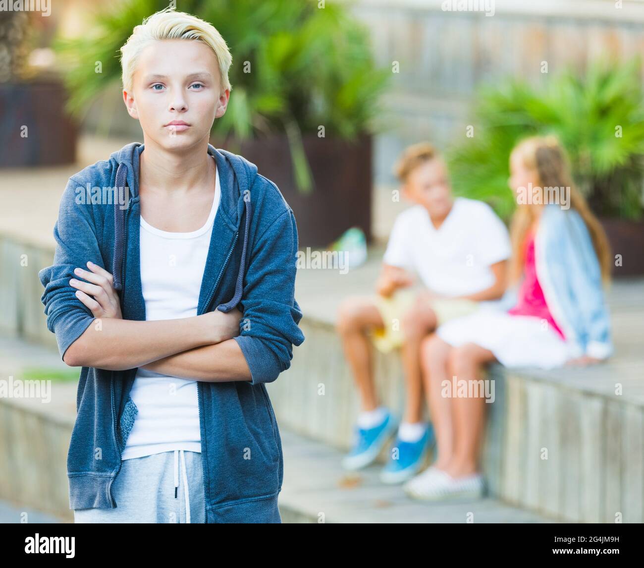 Sad boy having problems with friends Stock Photo - Alamy