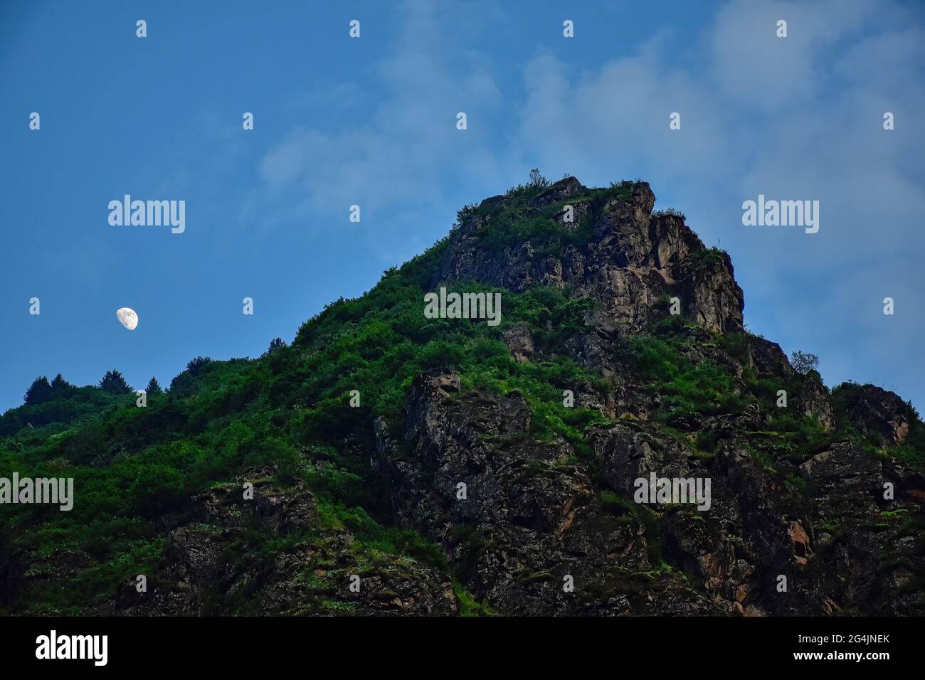 The Waxing Gibbous moon rises over the mountain on the outskirts of ...