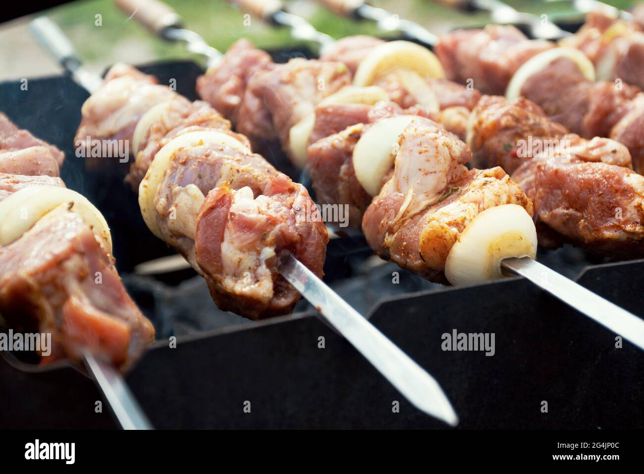Marinated shashlik preparing on a barbecue grill over charcoal ...