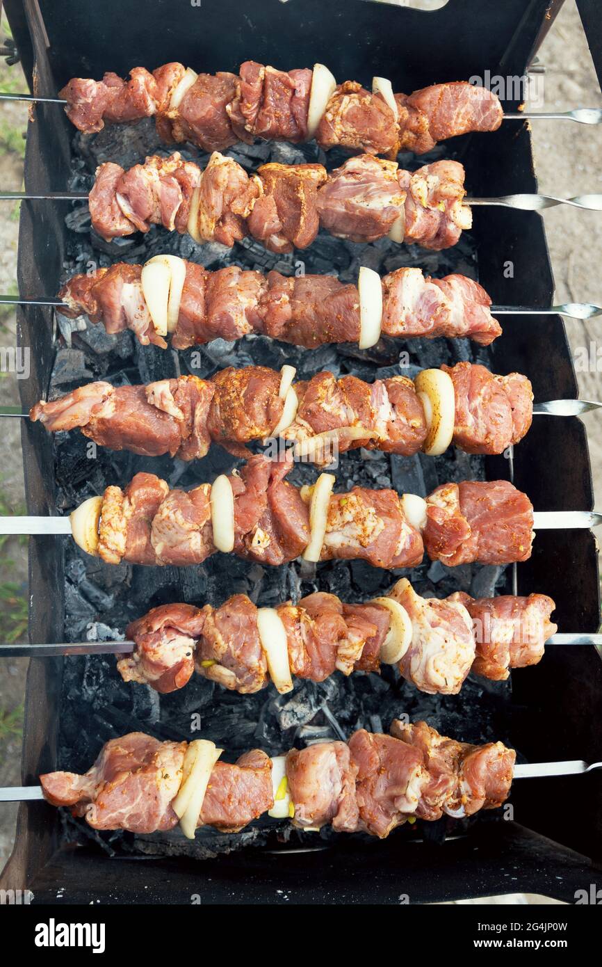 Marinated shashlik preparing on a barbecue grill over charcoal ...