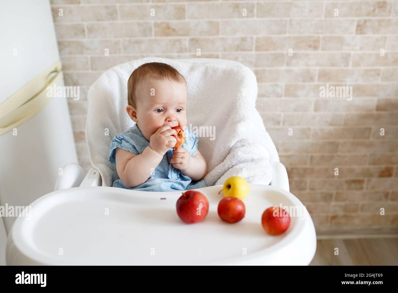 baby child in the kitchen eating healthy food fruits and vegetables ...