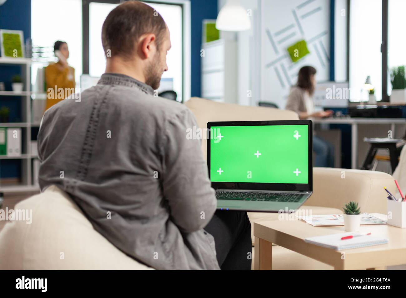 Business team sitting on couch analysing financial statistics, holding ...