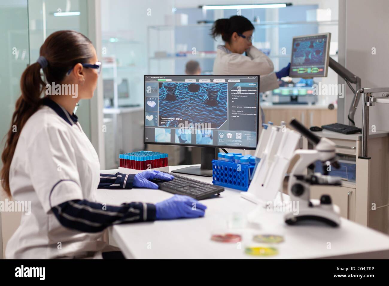Healthcare researcher working to discover a vaccine working on computer ...