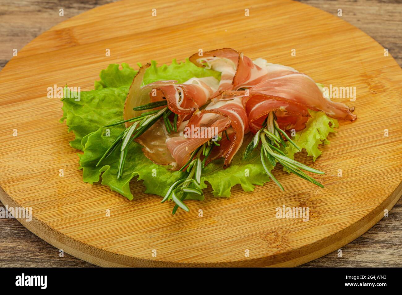 Sliced pork Jamon meat with rosemary Stock Photo - Alamy