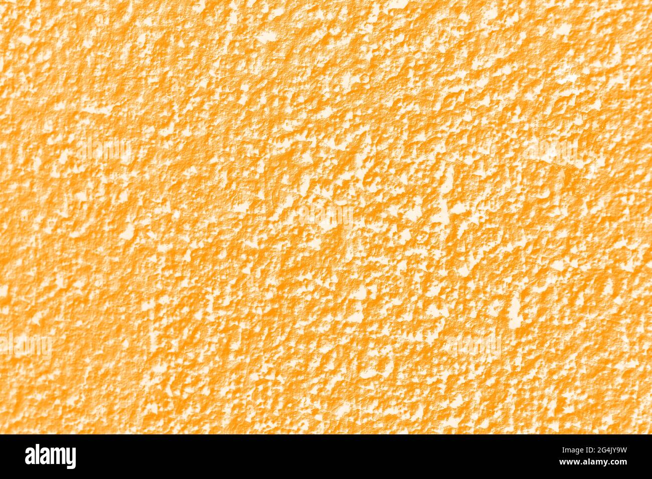 Old yellow stone wall with rough bumps and dents under bright light ...