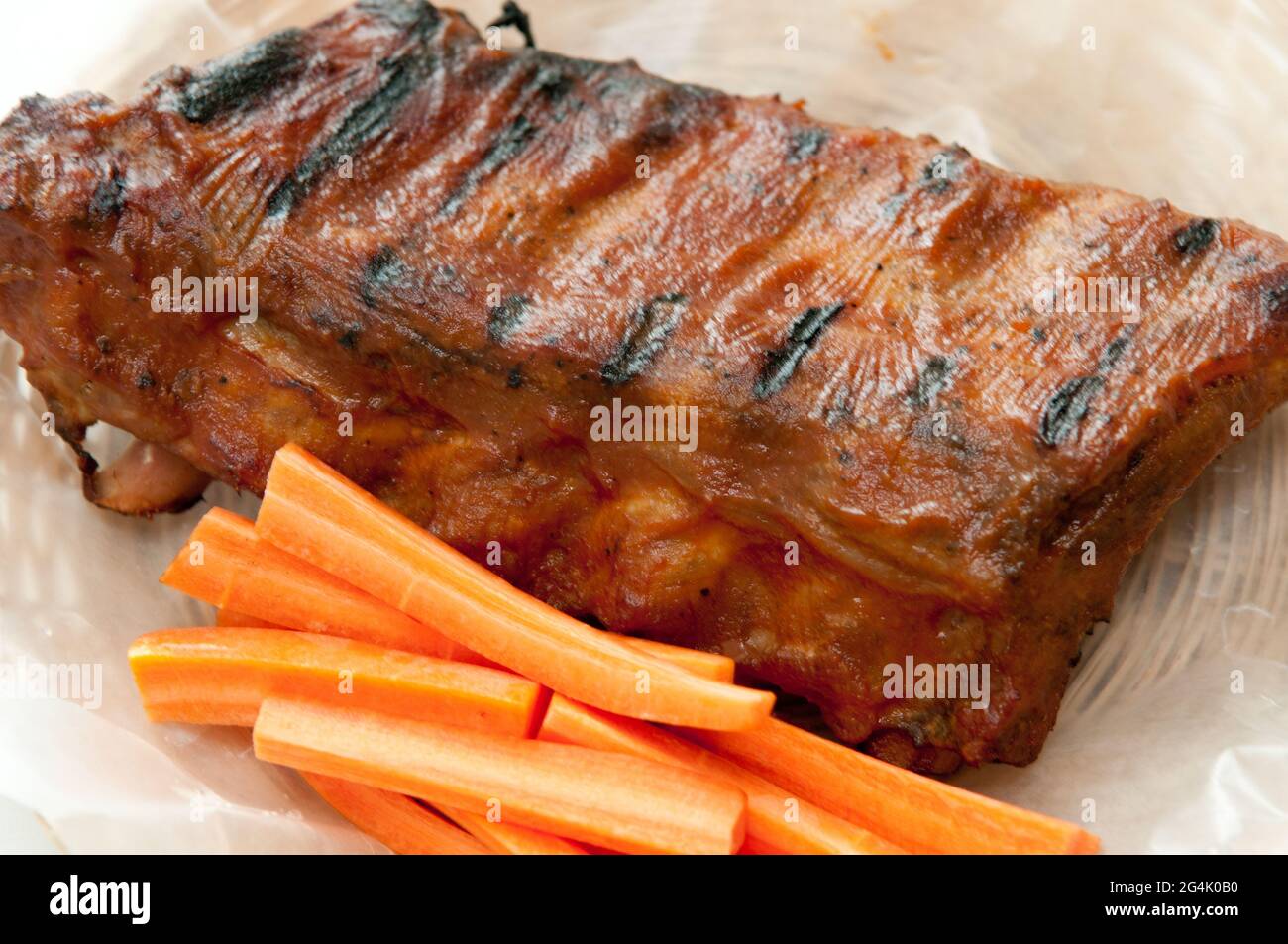 Closeup shot of an oven-roasted barbeque with carrots on a white ...