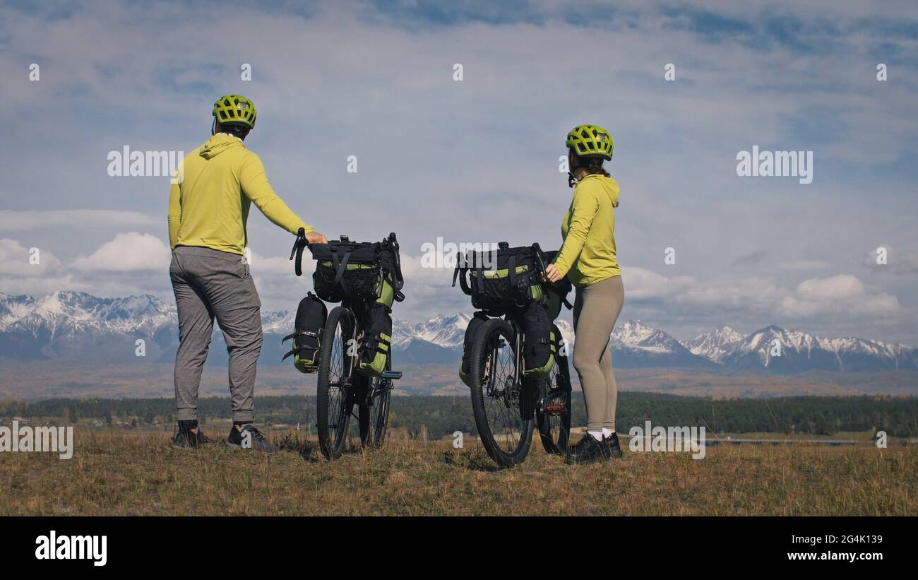 The man and woman travel on mixed terrain cycle touring with ...
