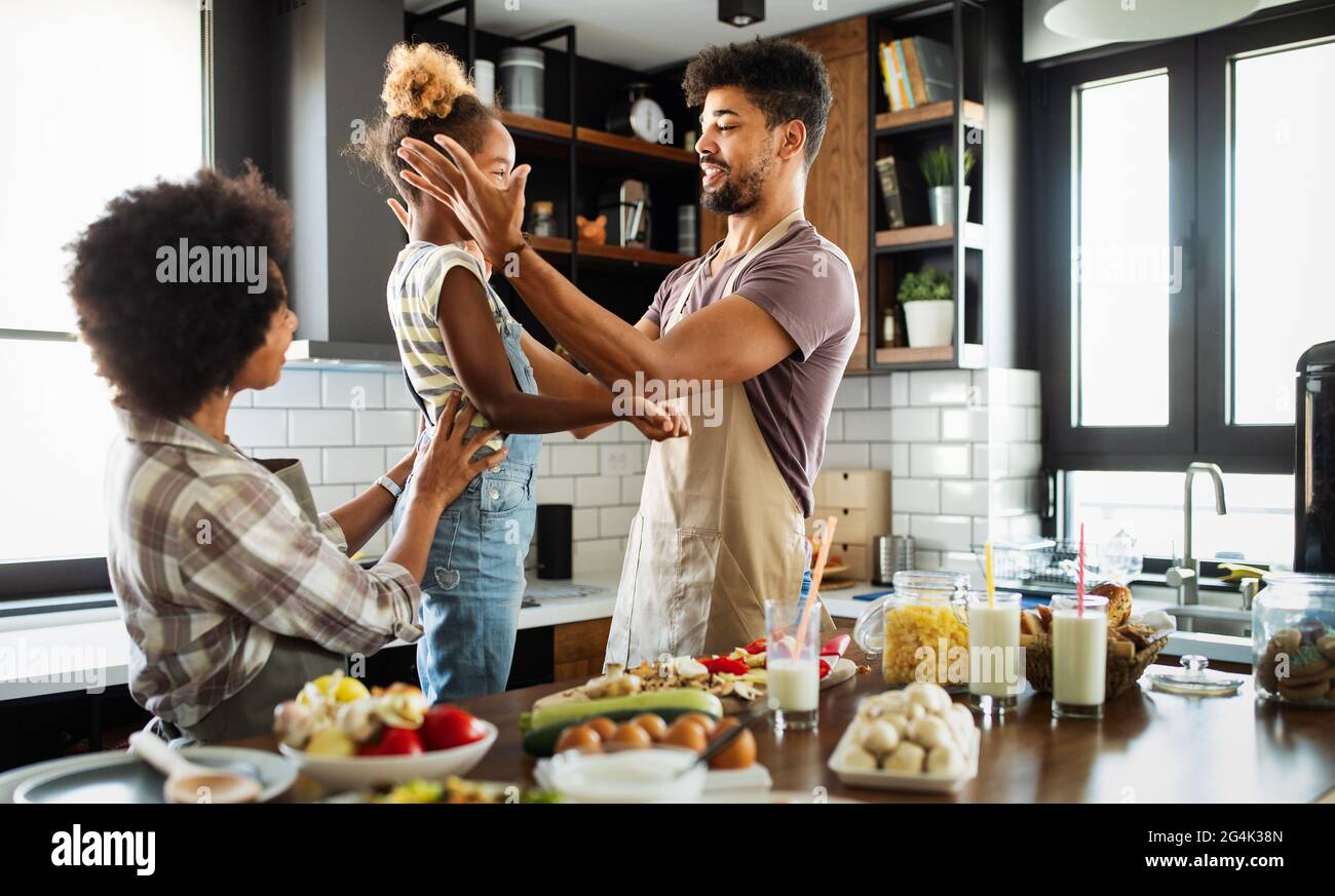 Happy family cooking together food in the kitchen Stock Photo - Alamy