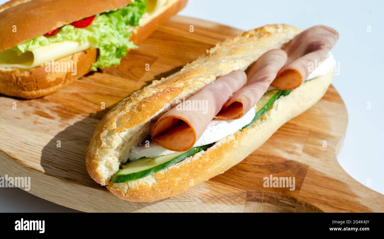 Closeup of submarine sandwiches on a wooden board isolated on white ...