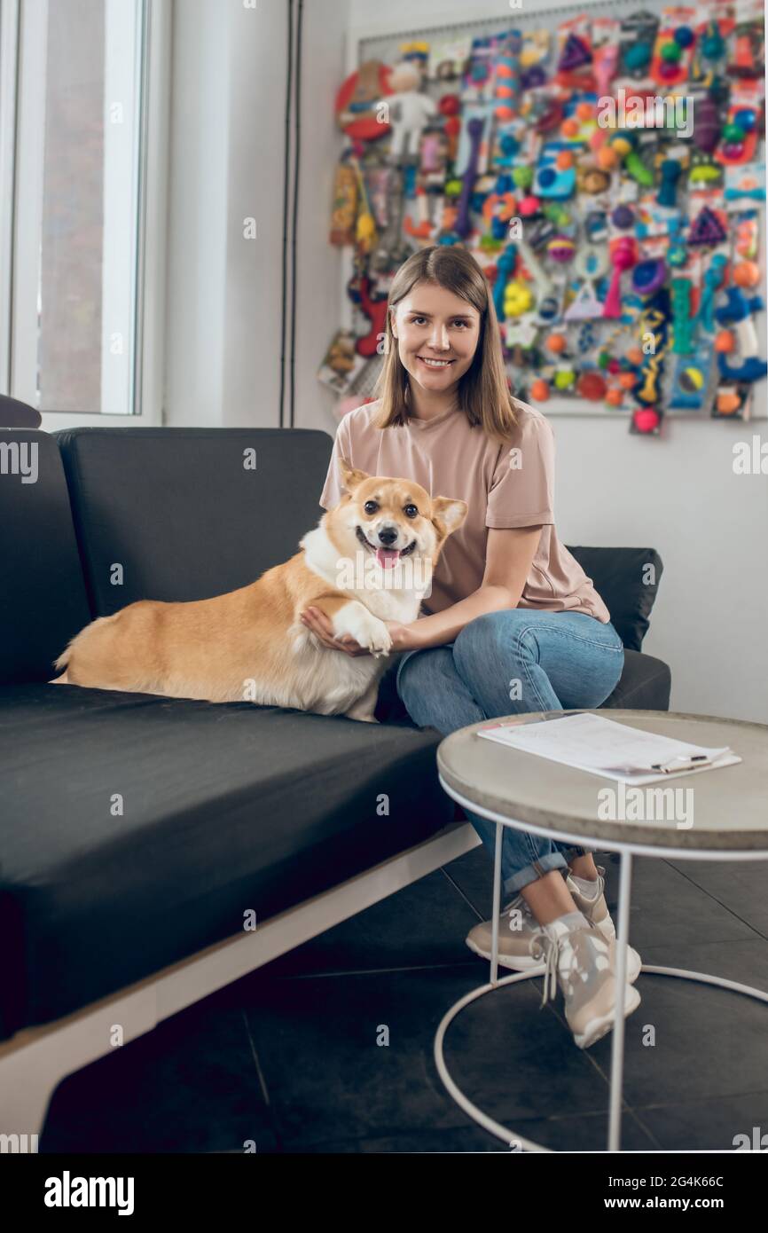 Female pet owner sitting on a sofa with her dog Stock Photo - Alamy