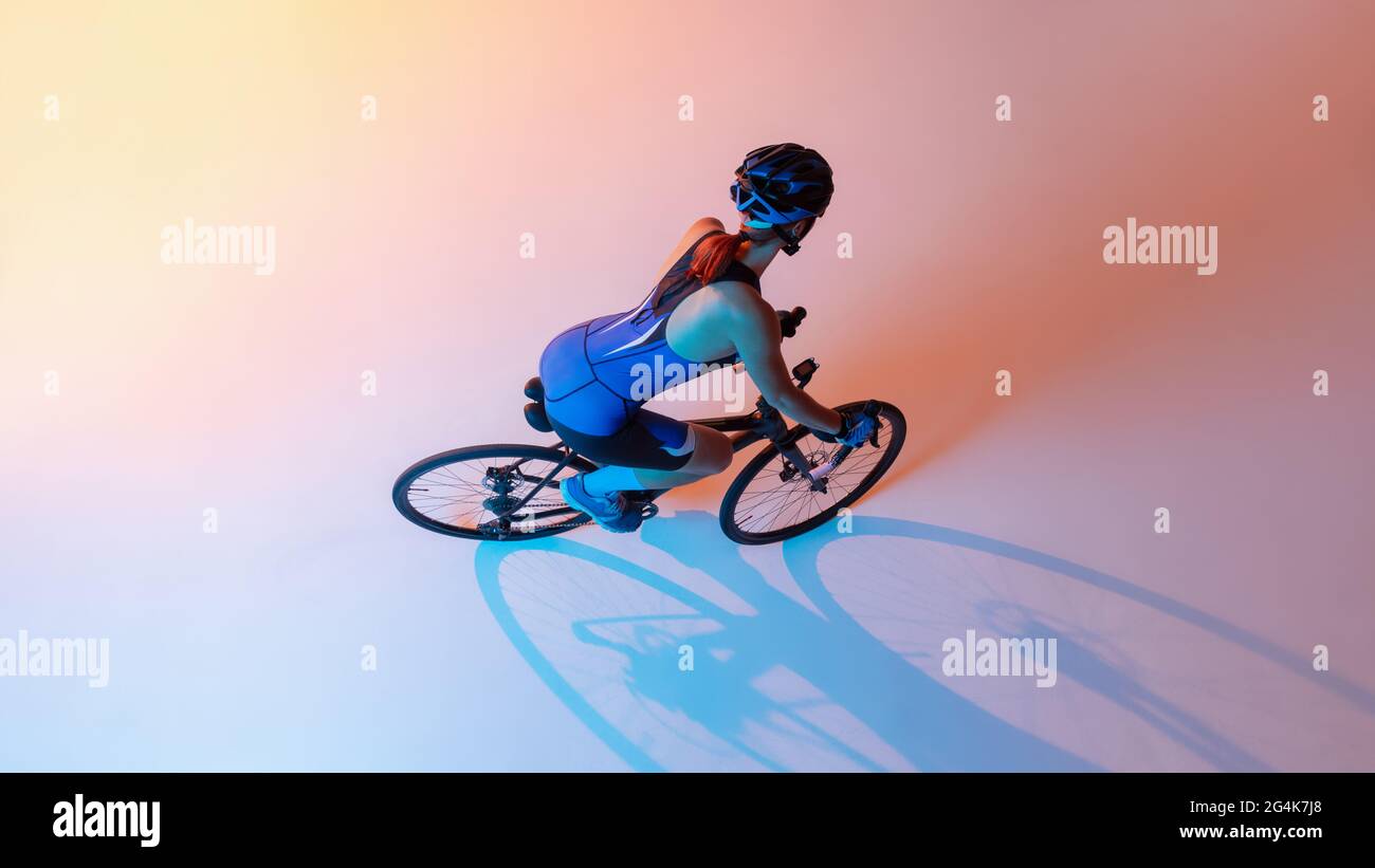 High angle view of female cyclist riding a bicycle isolated against ...
