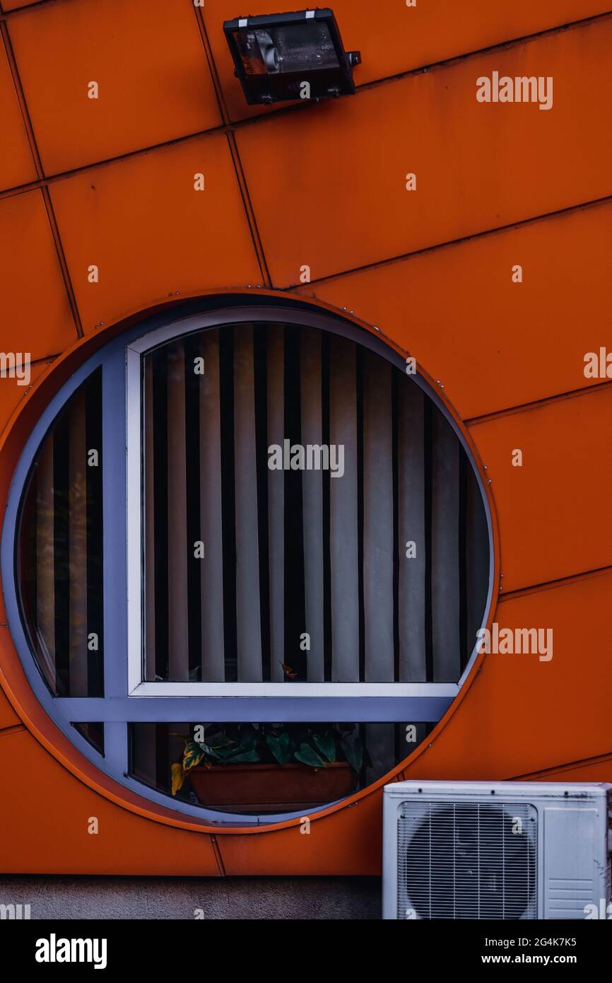 Round window in a orange building Stock Photo - Alamy