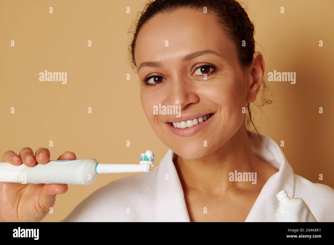 Isolated portrait on beige background of an attractive mixed race woman ...