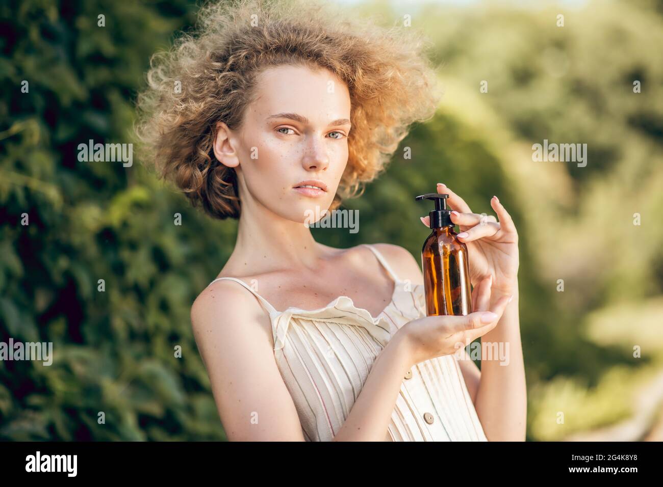 Pretty woman holding a bottle of essential organic oil in hands Stock ...