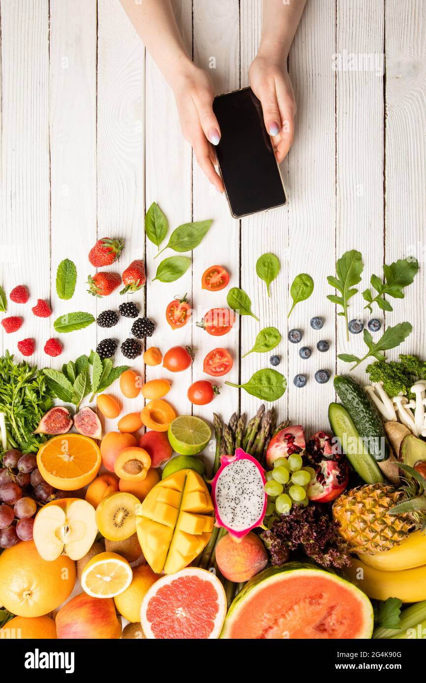 Ordering different fruits and vegetables using smartphones Stock Photo ...