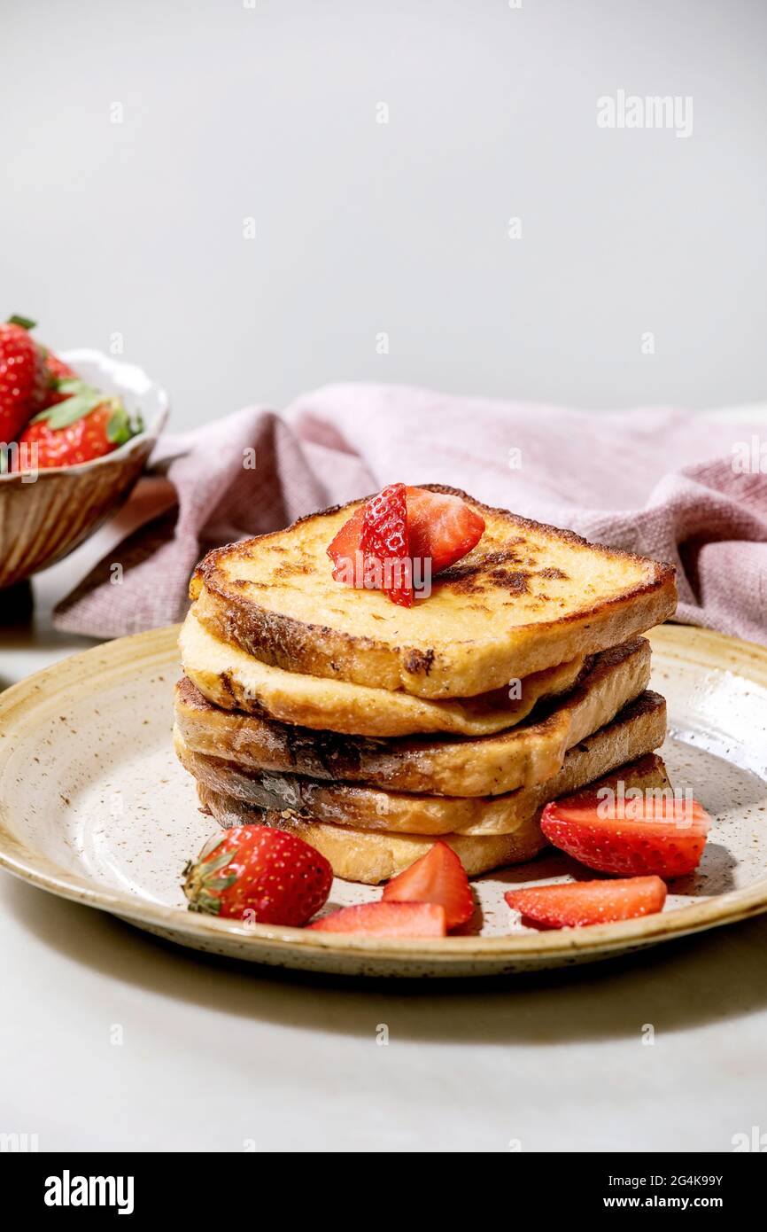 Stockpile of french toasts with fresh strawberries on ceramic plate and ...