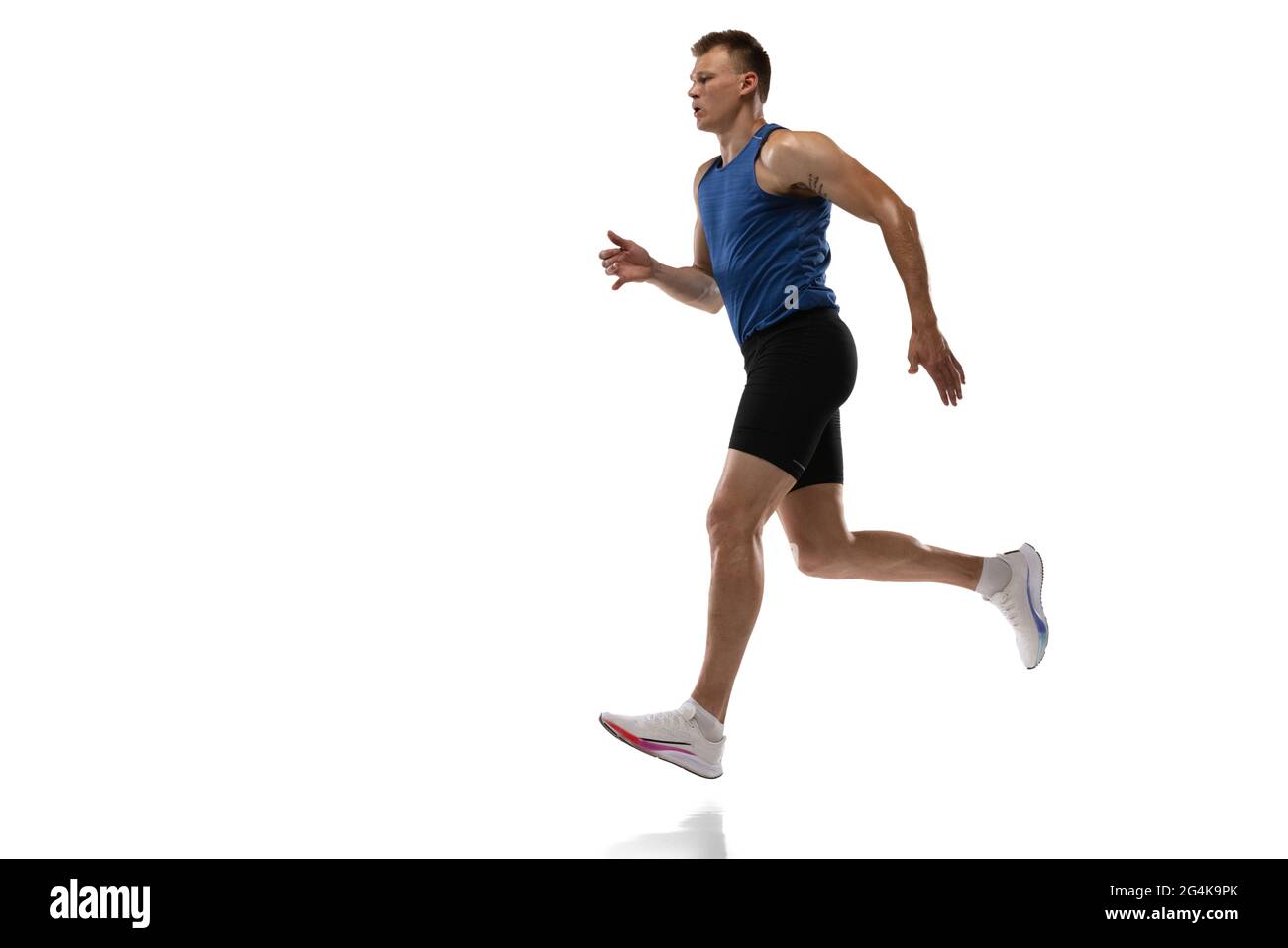 Caucasian professional male athlete, runner training isolated on white ...