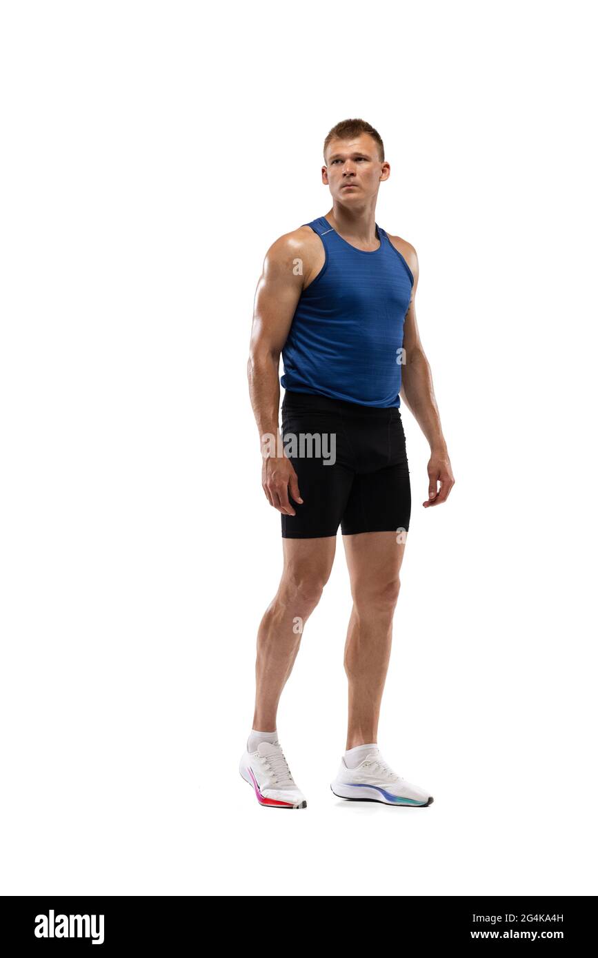 Caucasian professional male athlete, runner standing isolated on white ...