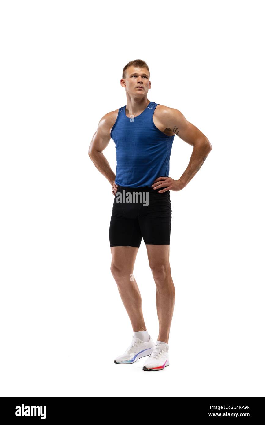 Caucasian professional male athlete, runner standing isolated on white ...