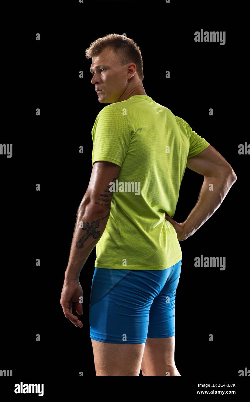 Caucasian professional male athlete, runner standing isolated on black ...