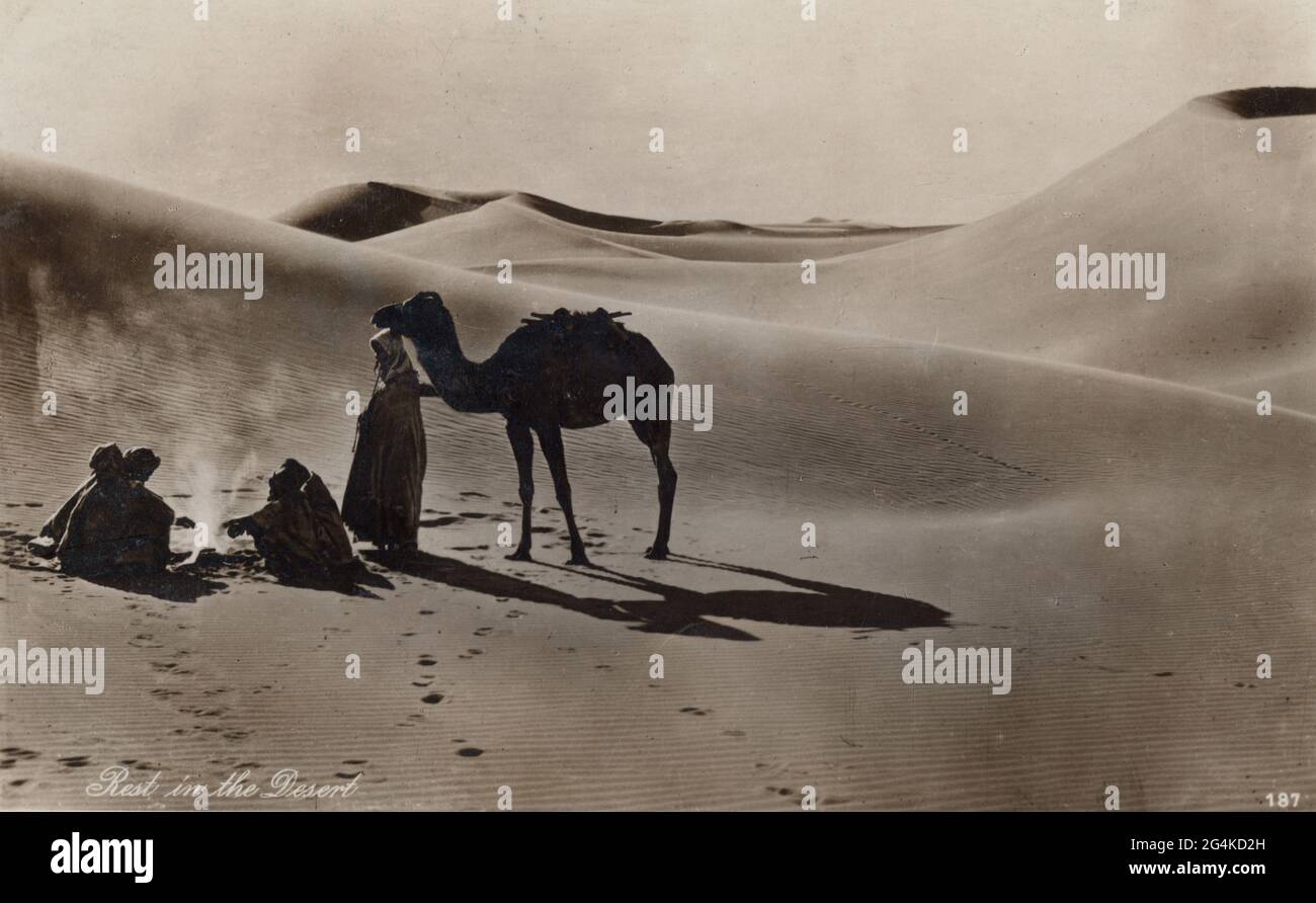 Rest in the Desert, 1930s. Arab men sitting round a campire among sand ...