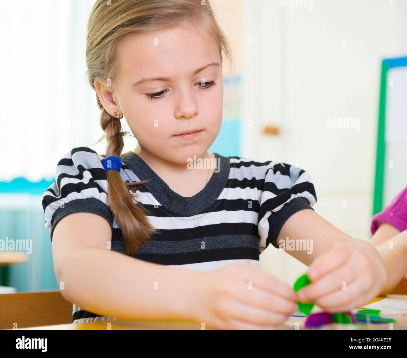 Cute little girl on lesson at kindergarten Stock Photo - Alamy