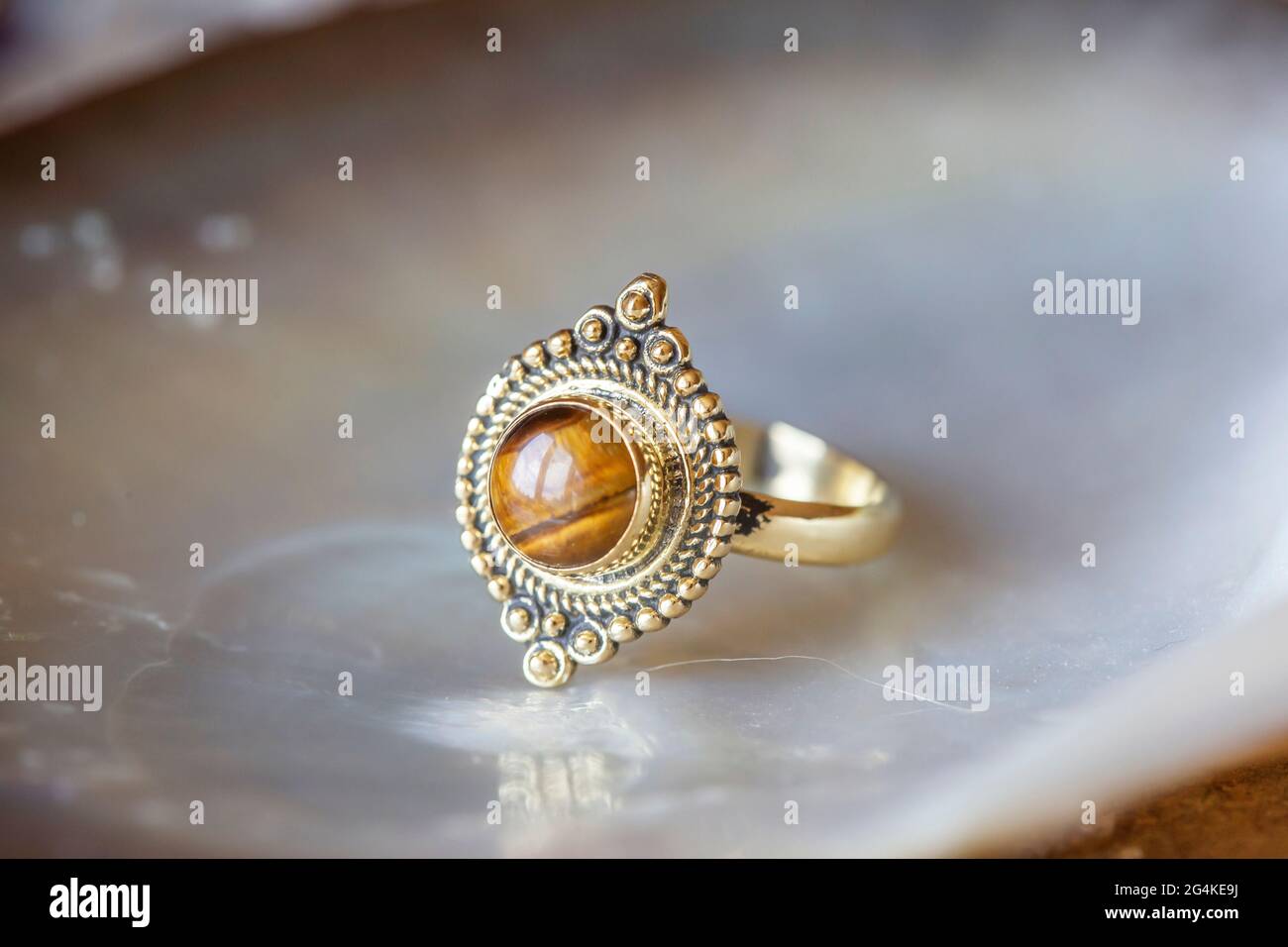 Brass ring in Indian oriental style on natural neutral shell background ...
