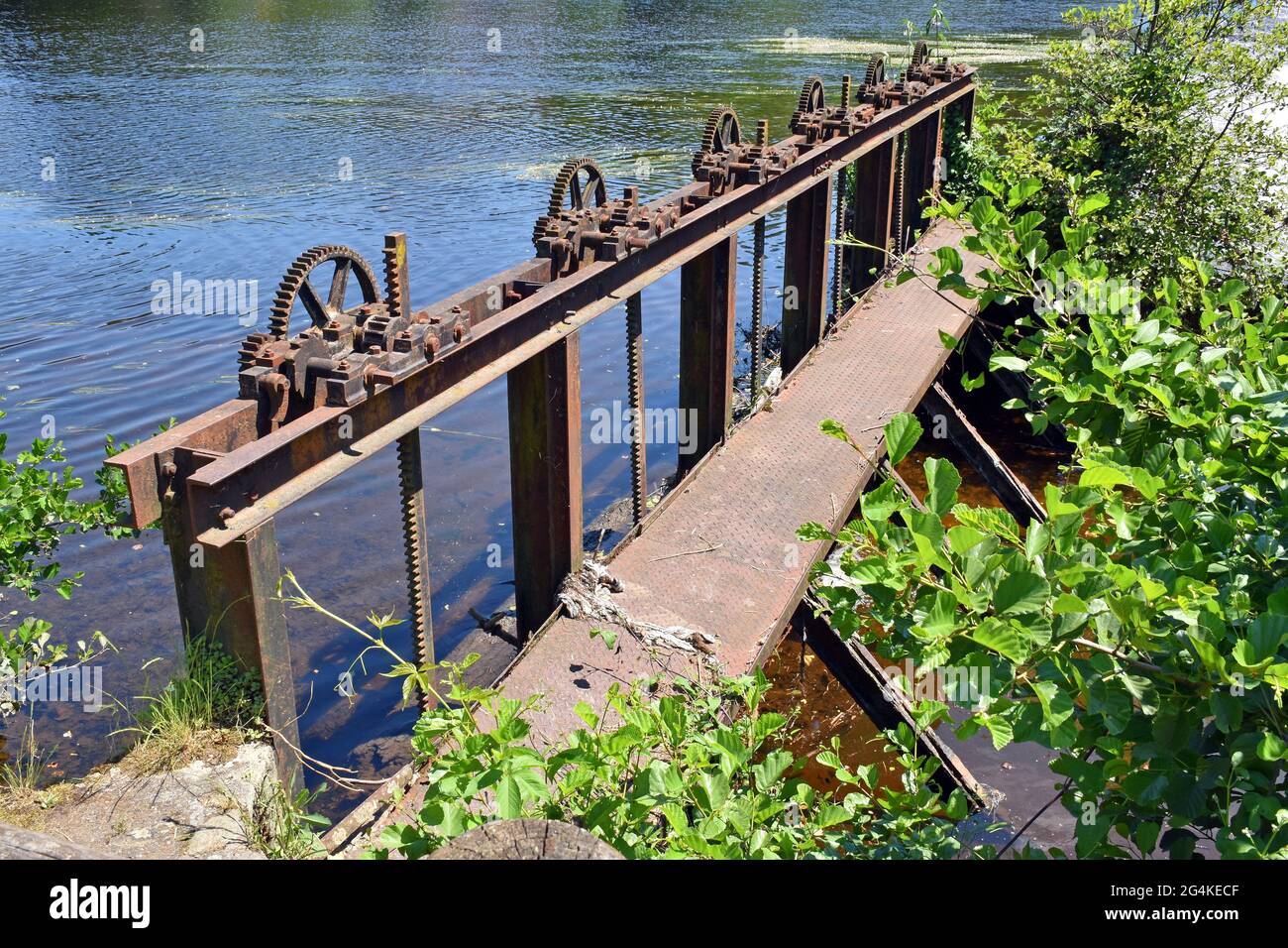 The rusting remains of a gate at one end of a weir across the river ...