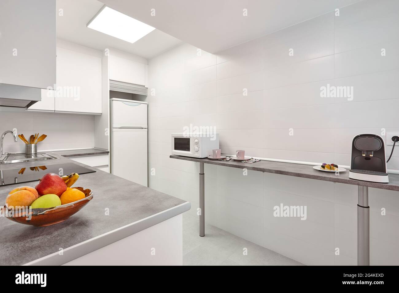 Small contemporary clean white kitchen with basic kitchenware. Indoor ...